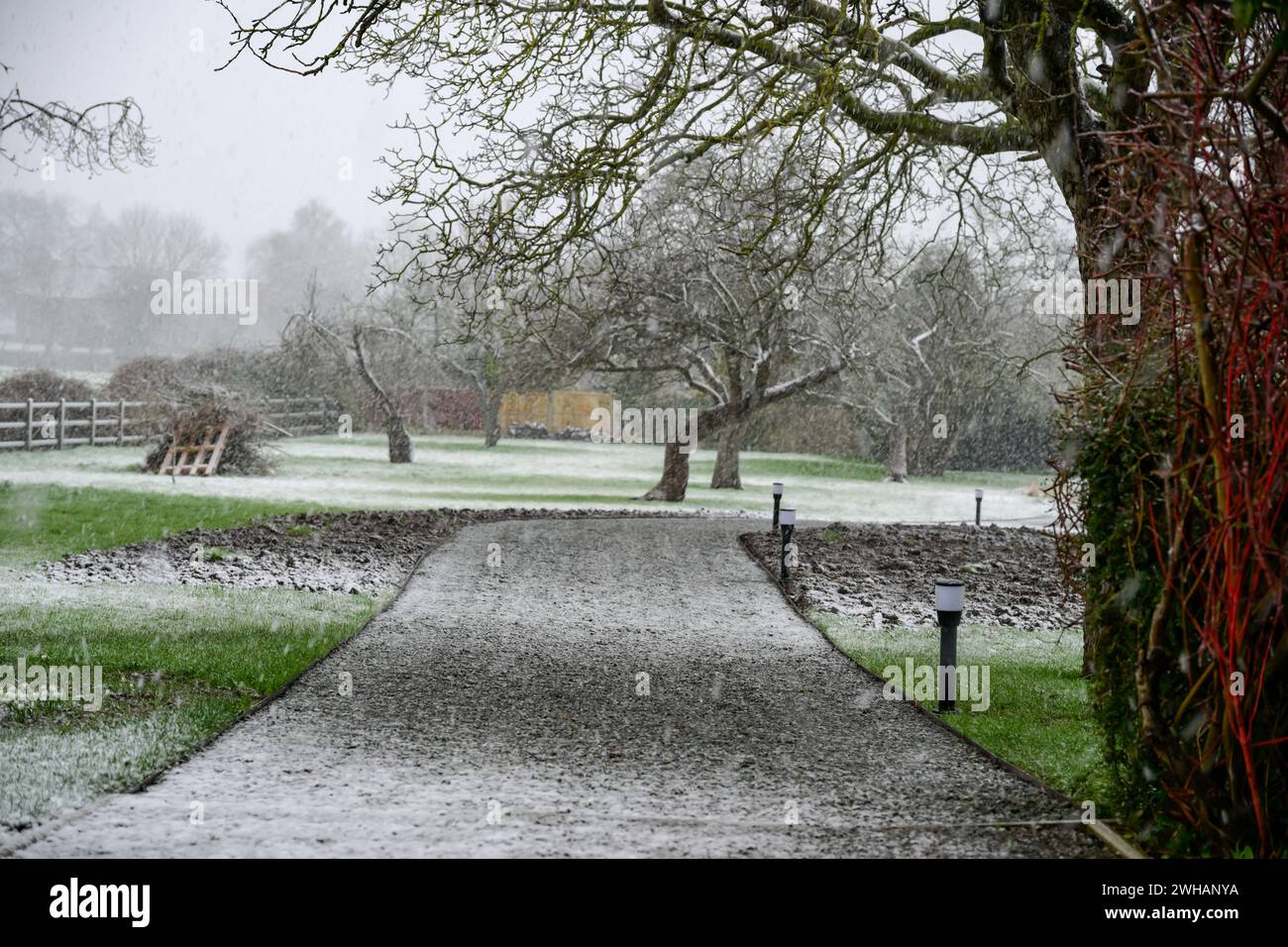 A view down a driveway with a sprinkling of snow Stock Photo - Alamy