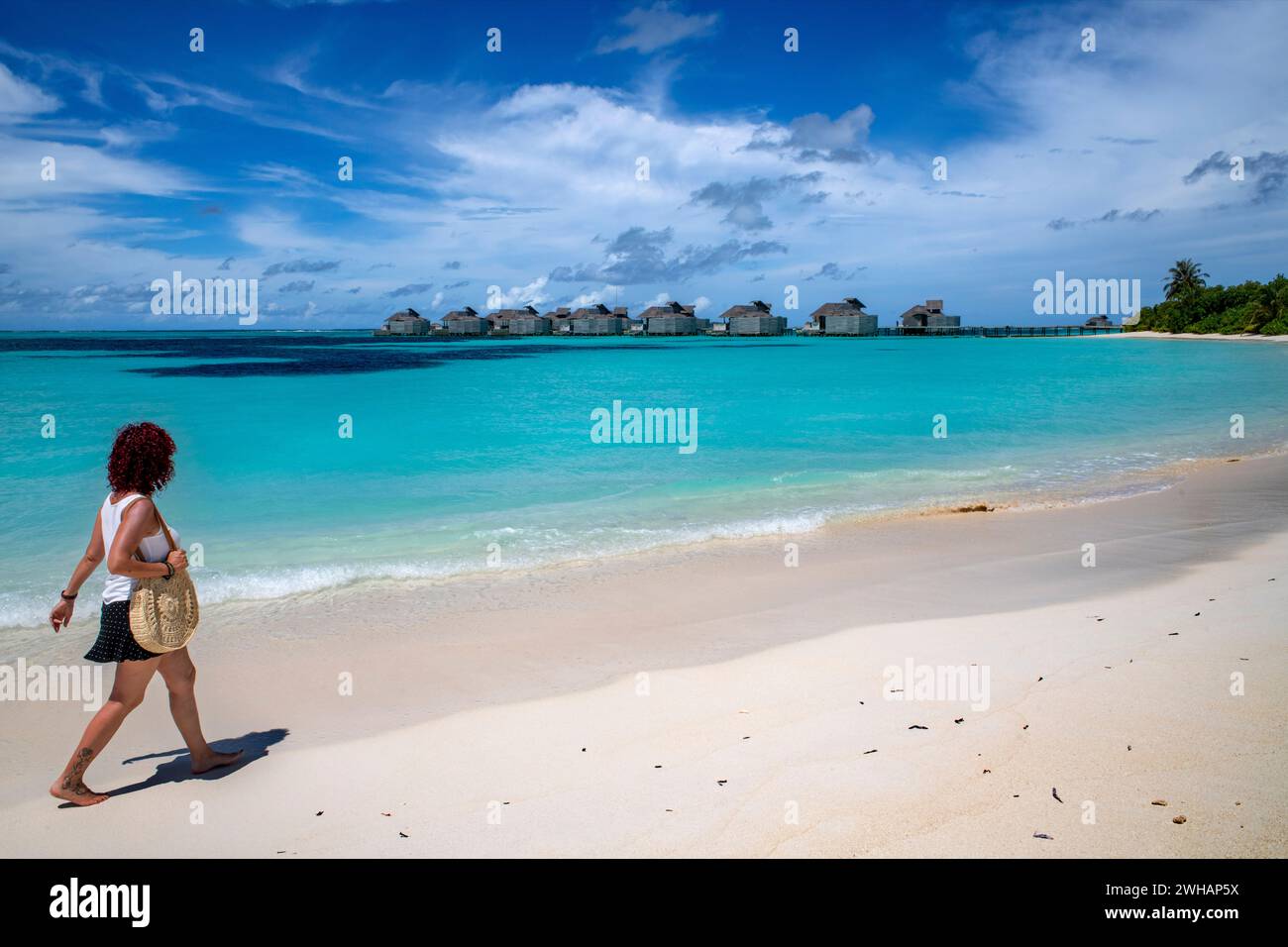 Walking on the white beach of the the luxury hotel Six Senses Laamu ...