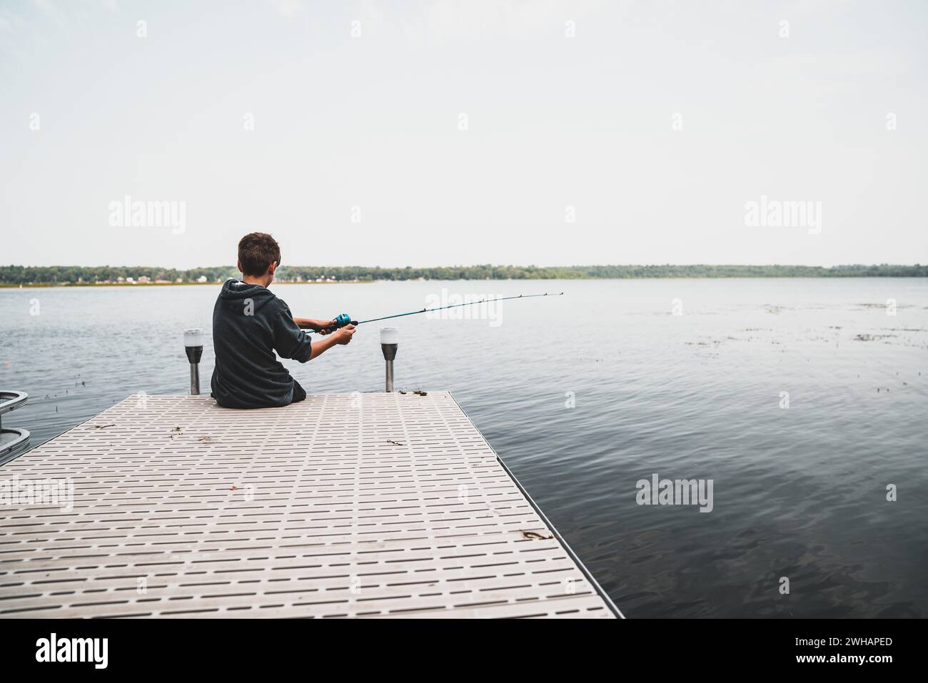 Young Boy Goes Fishing Off A Dock Stock Photo - Alamy