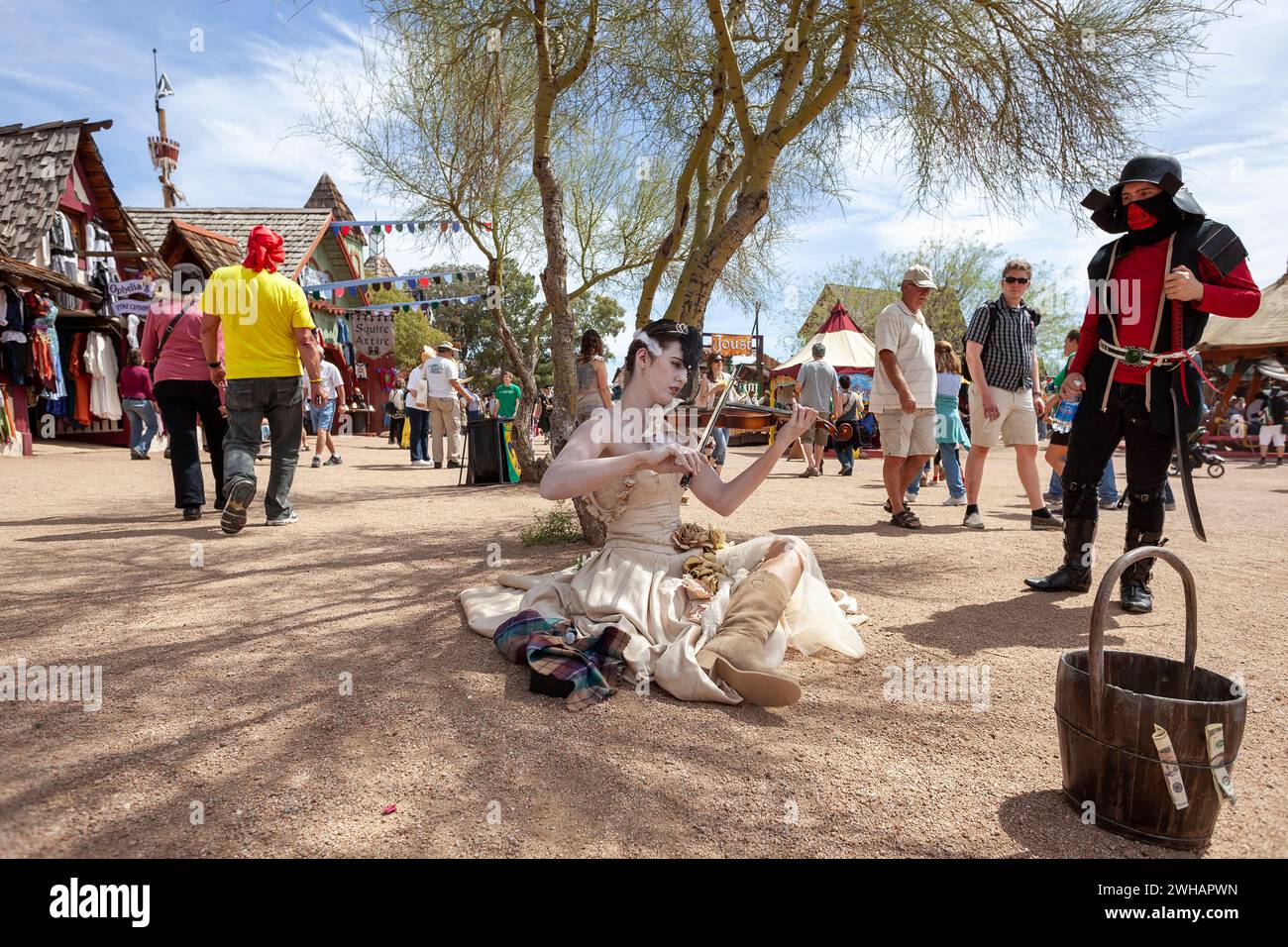 Passers by at a renaissance fair watching performers in costume Stock ...