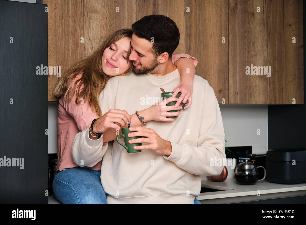 Spanish young couple hug in love while have a coffee in kitchen Stock ...
