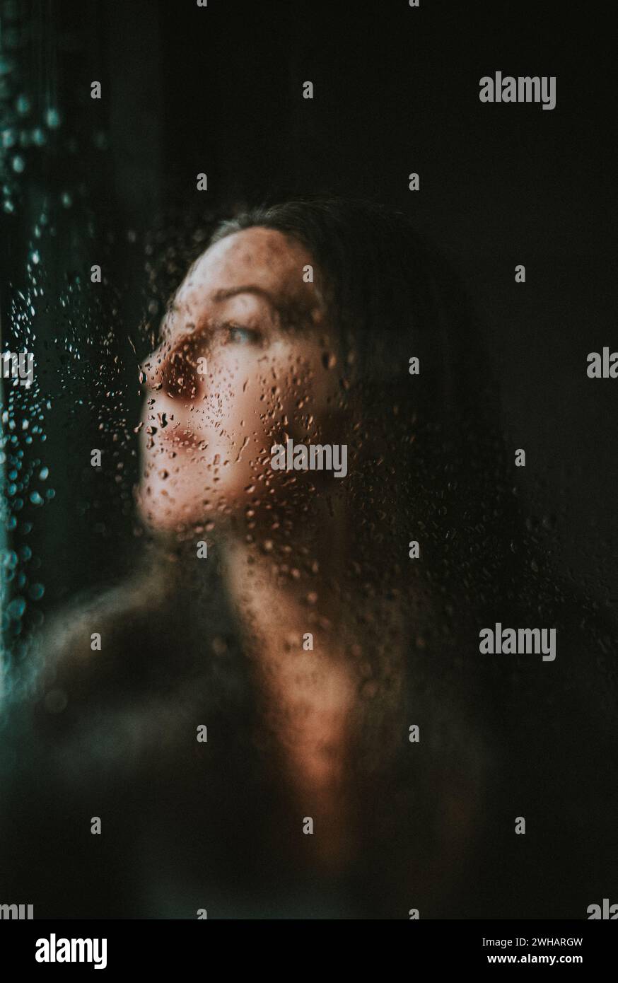 Woman's face behind a window pane covered in rain drops Stock Photo - Alamy