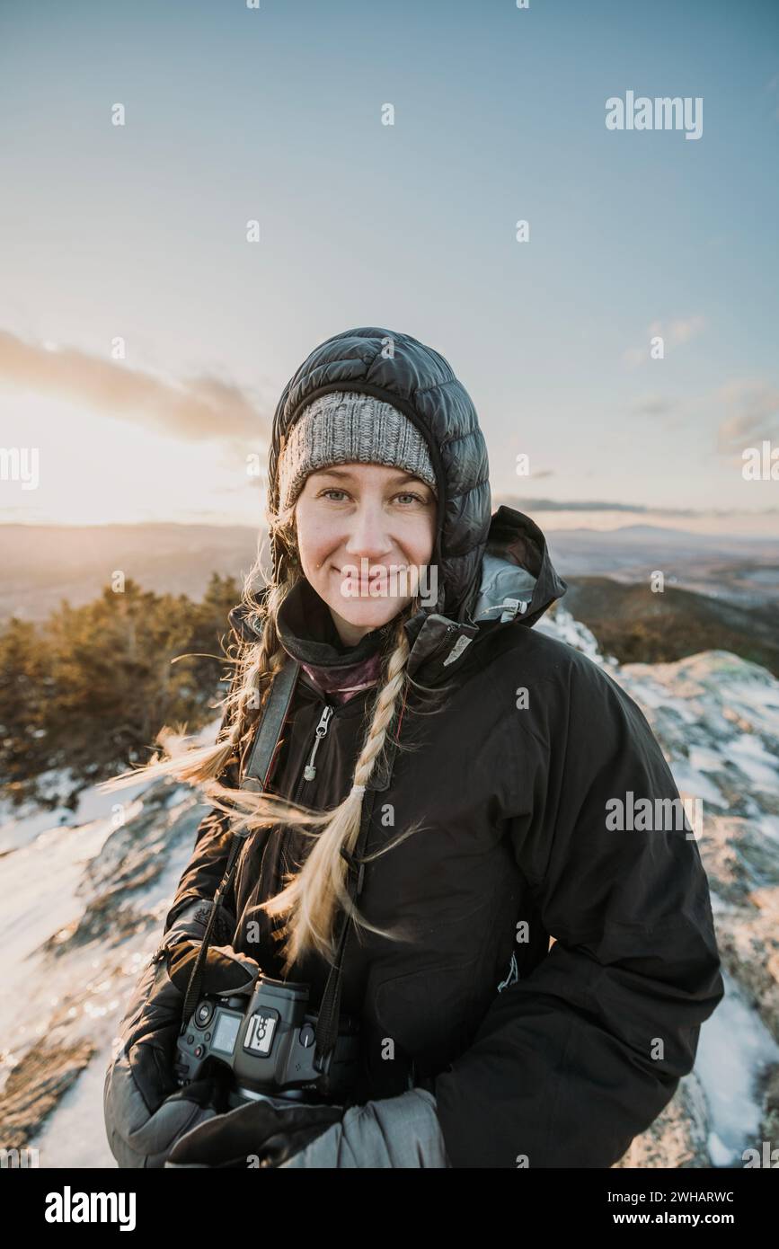 Portrait of young woman hiking in winter with camera around neck Stock ...