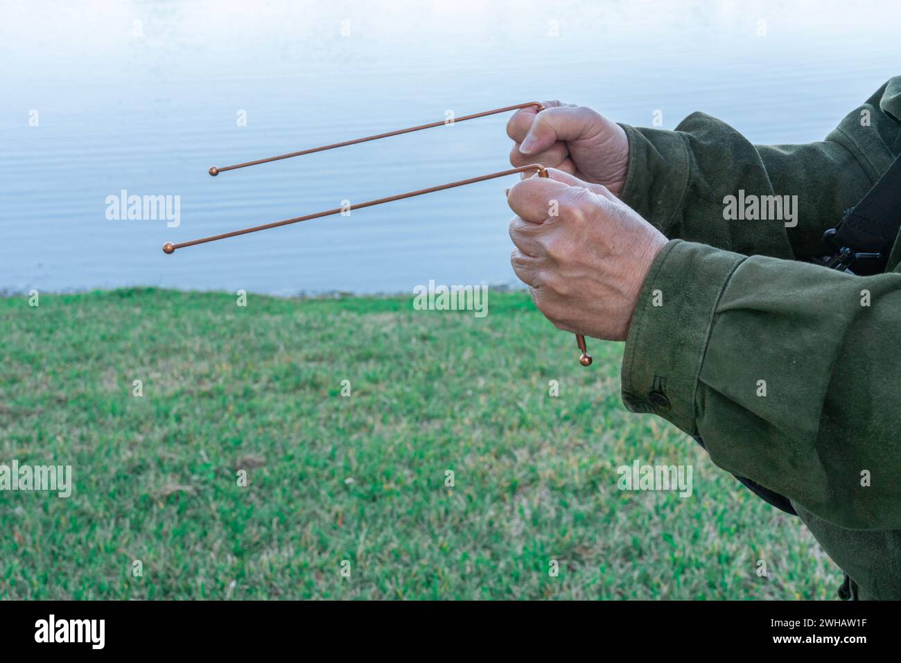 A person using dowsing rods to discover the source of water Stock Photo ...