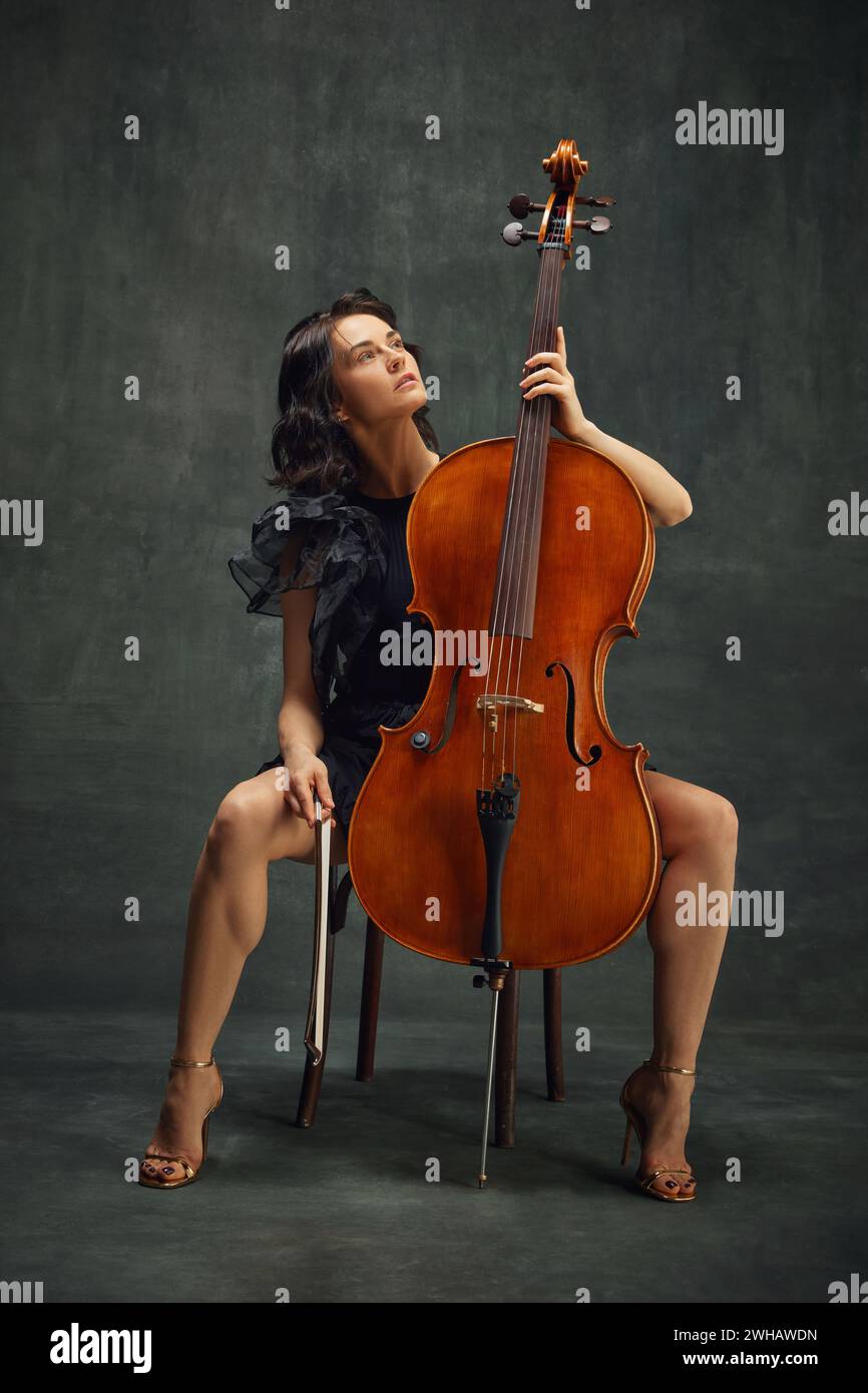 Beautiful woman, talented, passionate cellist looking upward ...