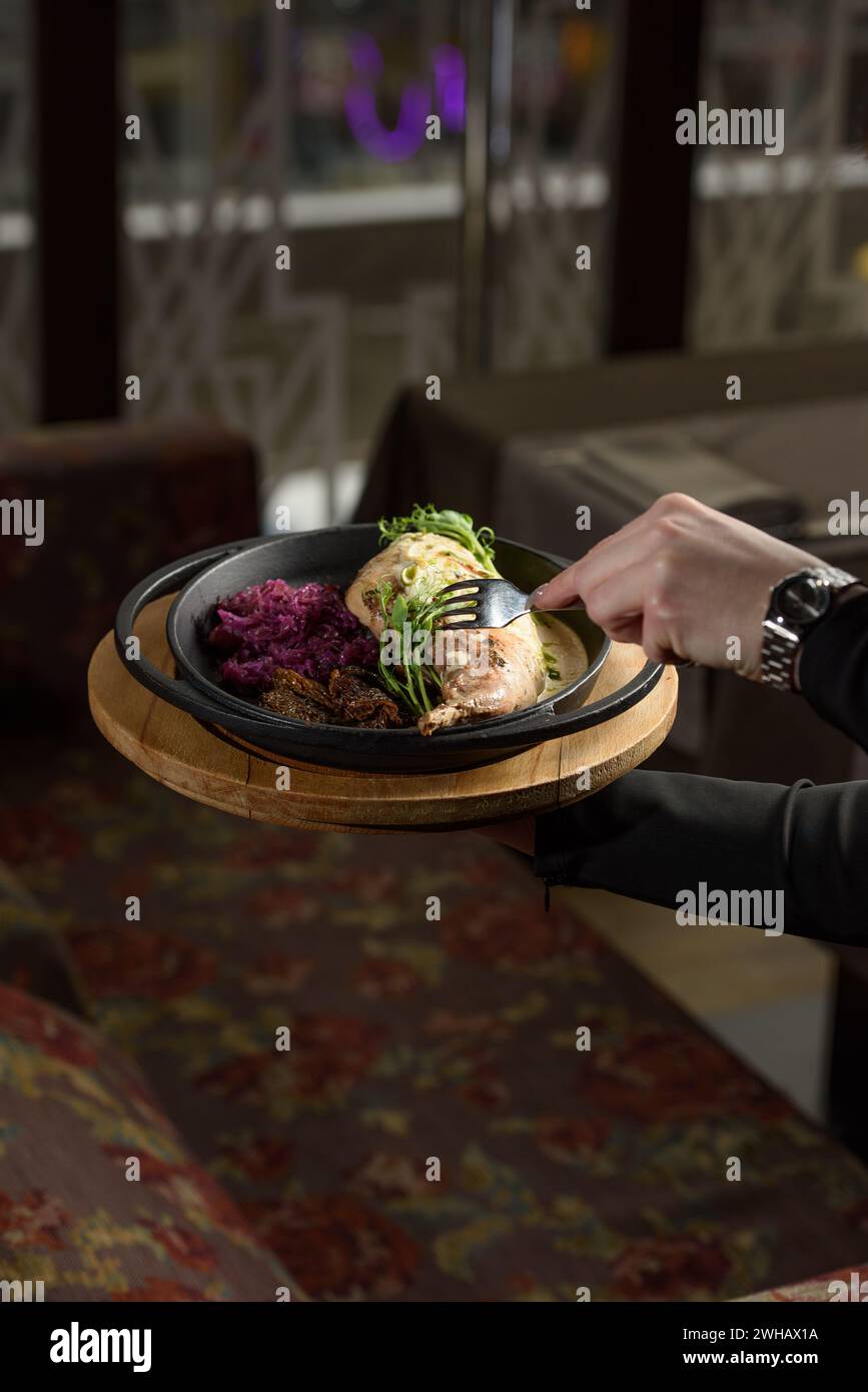 Chicken leg stuffed, served with vegetables on a black plate Stock ...