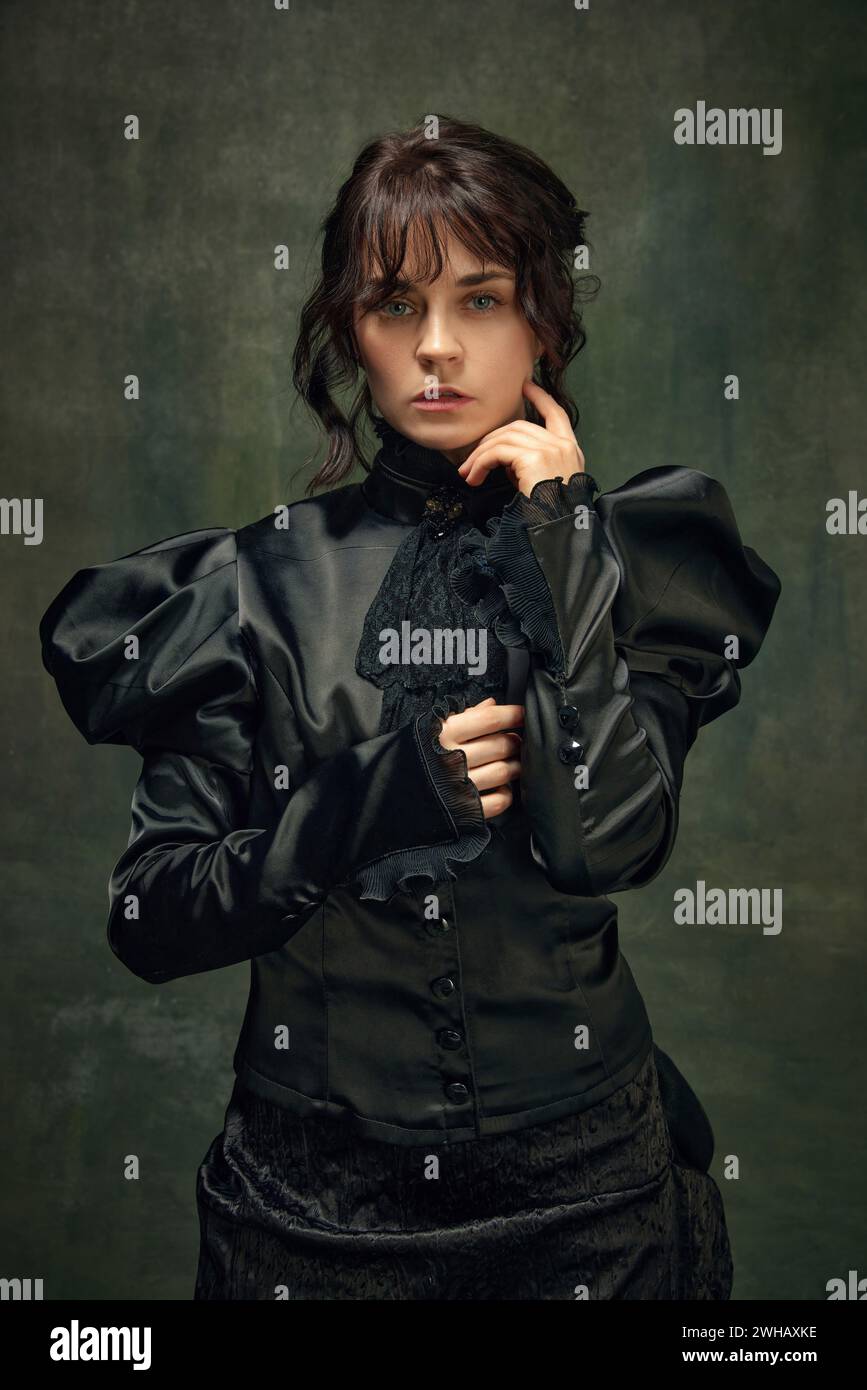 Portrait of beautiful, elegant young woman in Victorian black dress ...