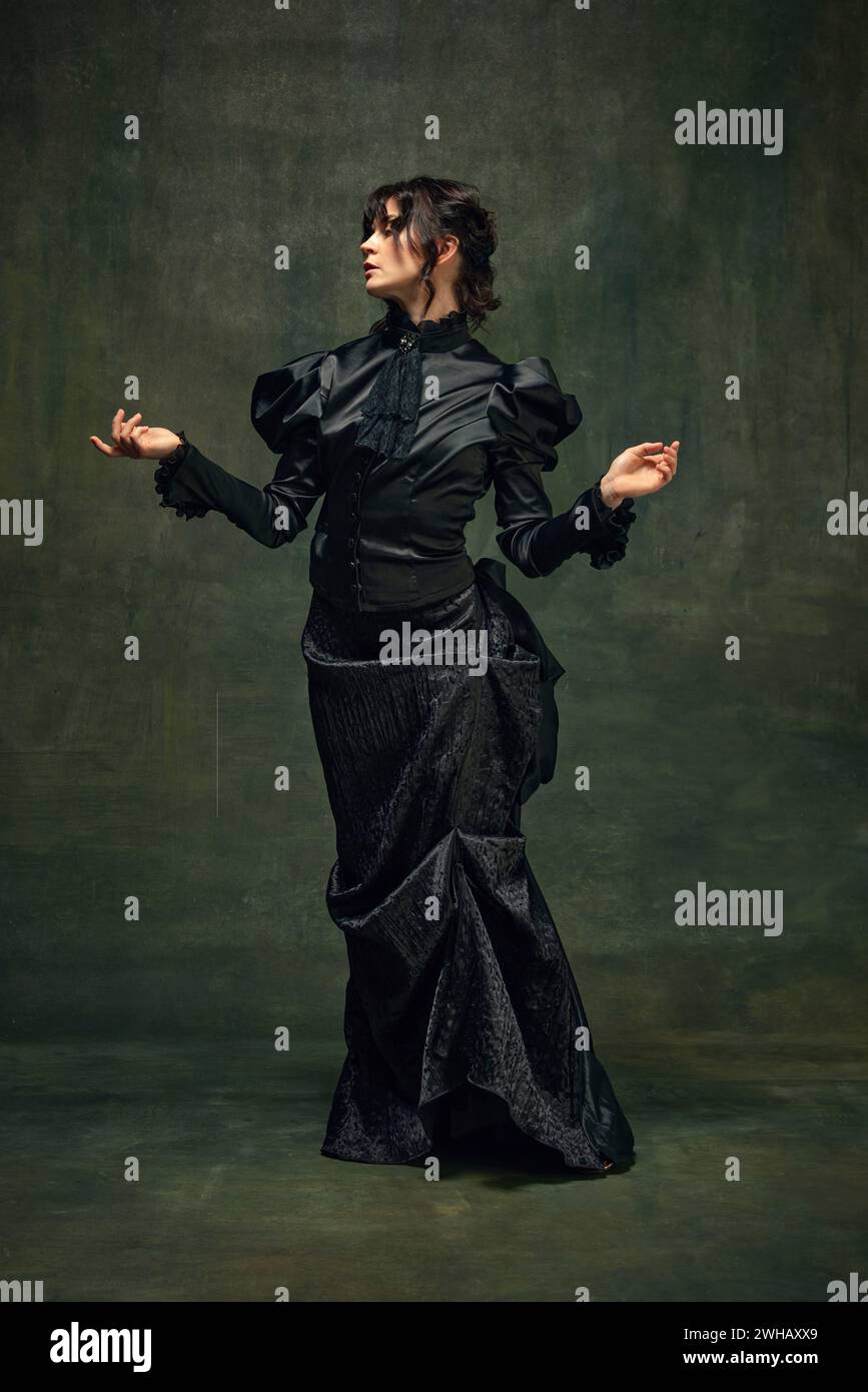 Woman in Victorian style black dress, standing in a dramatic pose ...