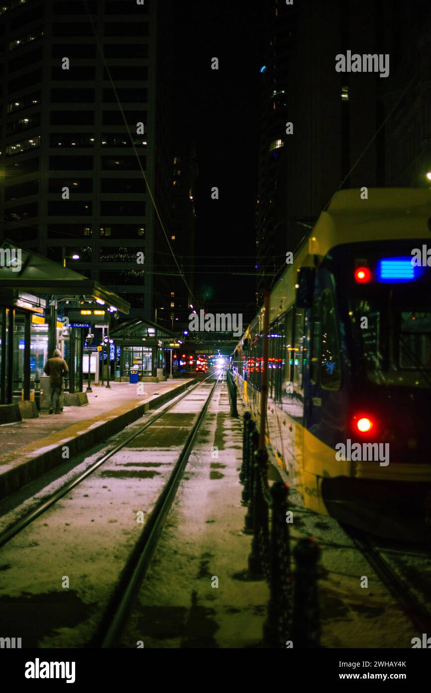 A nighttime scene of a train parked at a train station amidst city ...