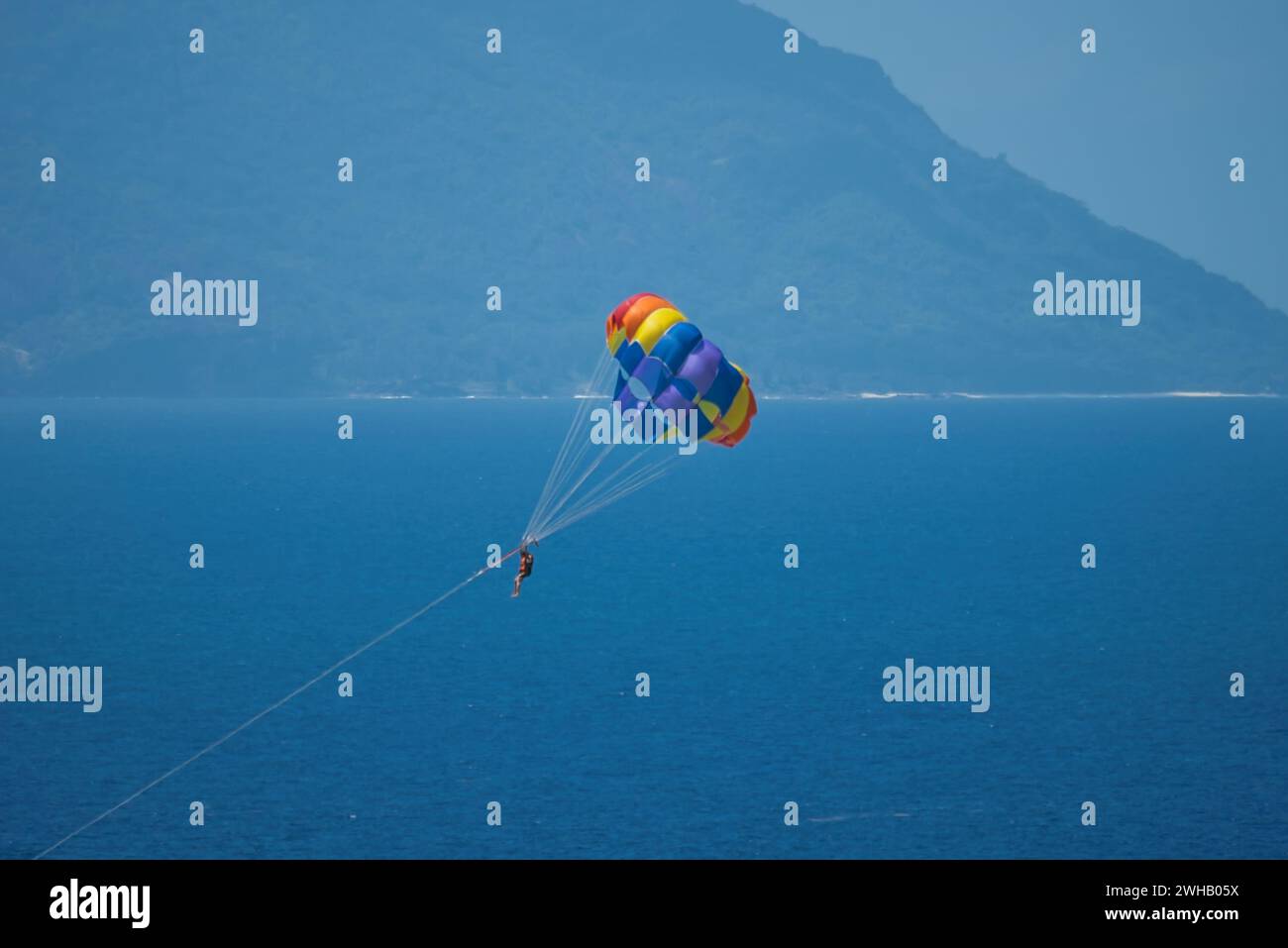 Single person paragliding from boat at beau vallon beach, Mahe ...
