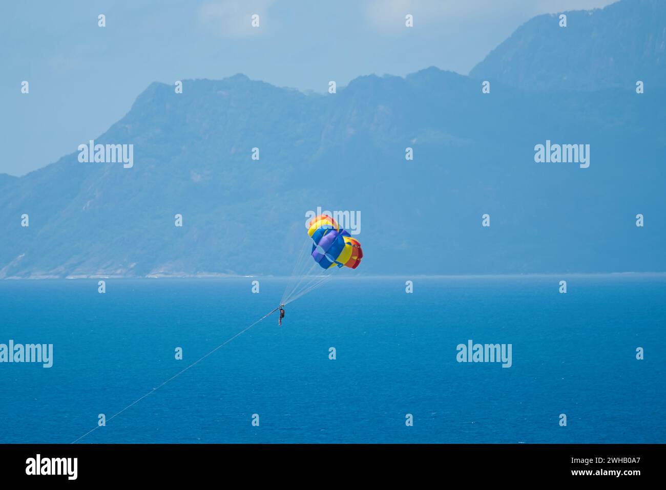 Single person paragliding from boat at beau vallon beach, Mahe ...