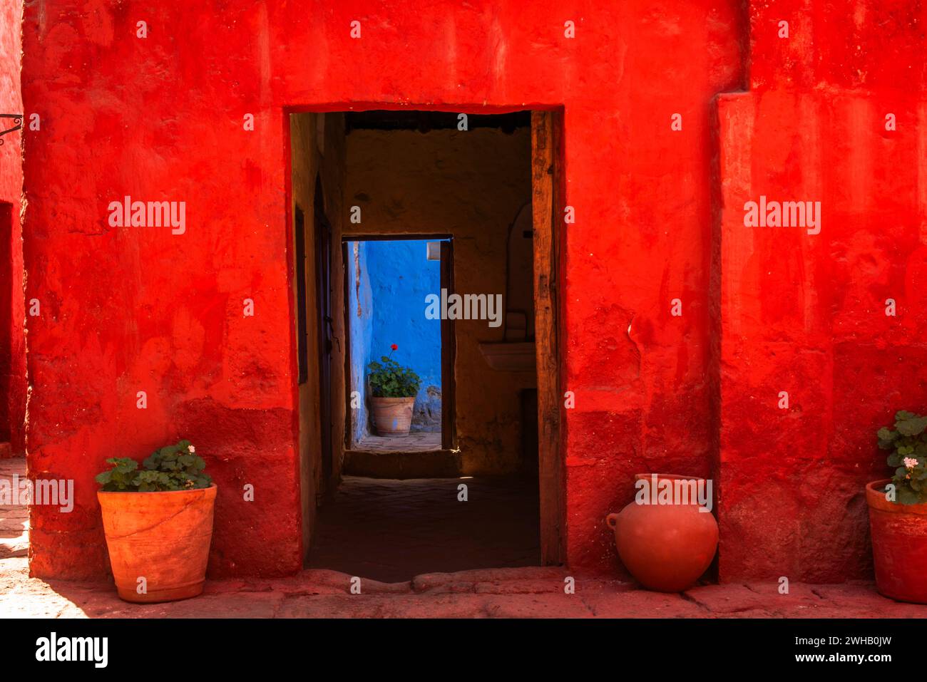 ancient doors on red and blue walls inside a monastery in Cusco Inca ...
