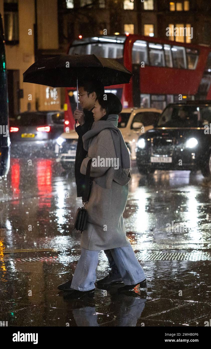 Tourists with umbrellas on a rainy winter's night in Aldwych, London's ...