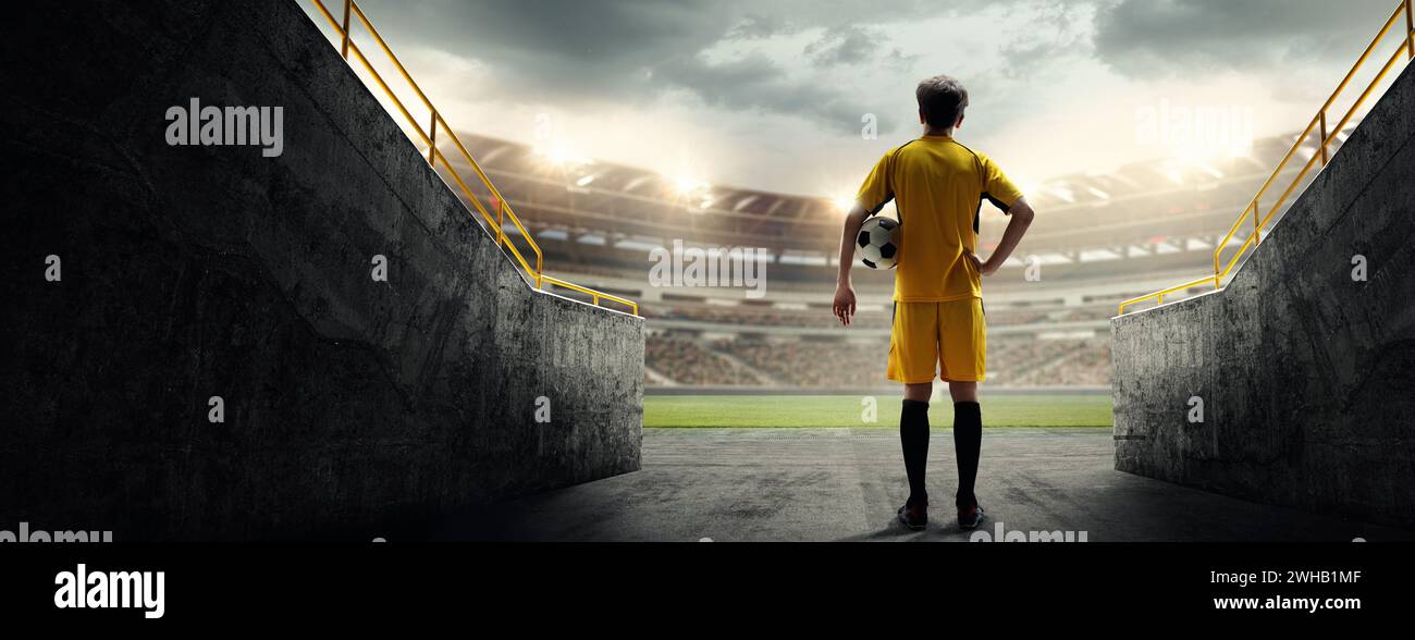 Young guy, soccer player in yellow uniform standing with football ball ...