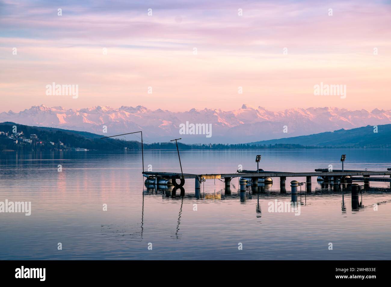 Summer shot over lake hallwil in Switzerland with beautiful colored clouds and the alps in the ...