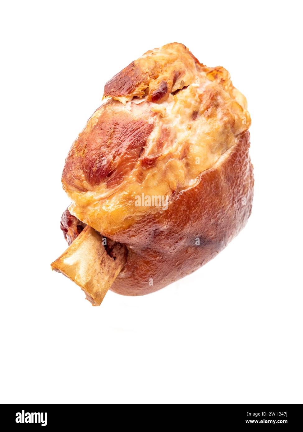 A close-up of a succulent pork knuckle served on a pristine white ...