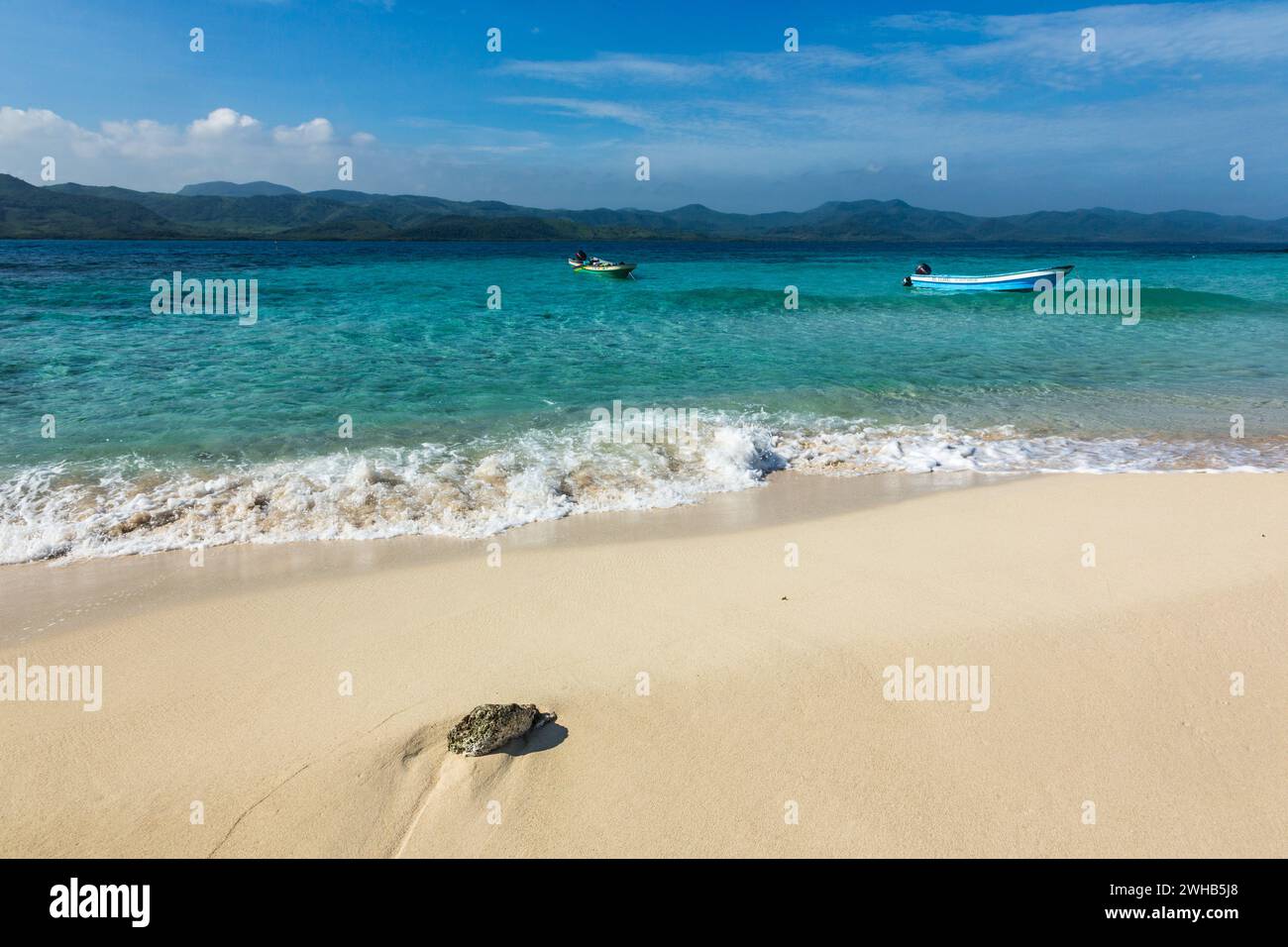Motor launches are moored in the clear shallow water around Cayo Arena ...