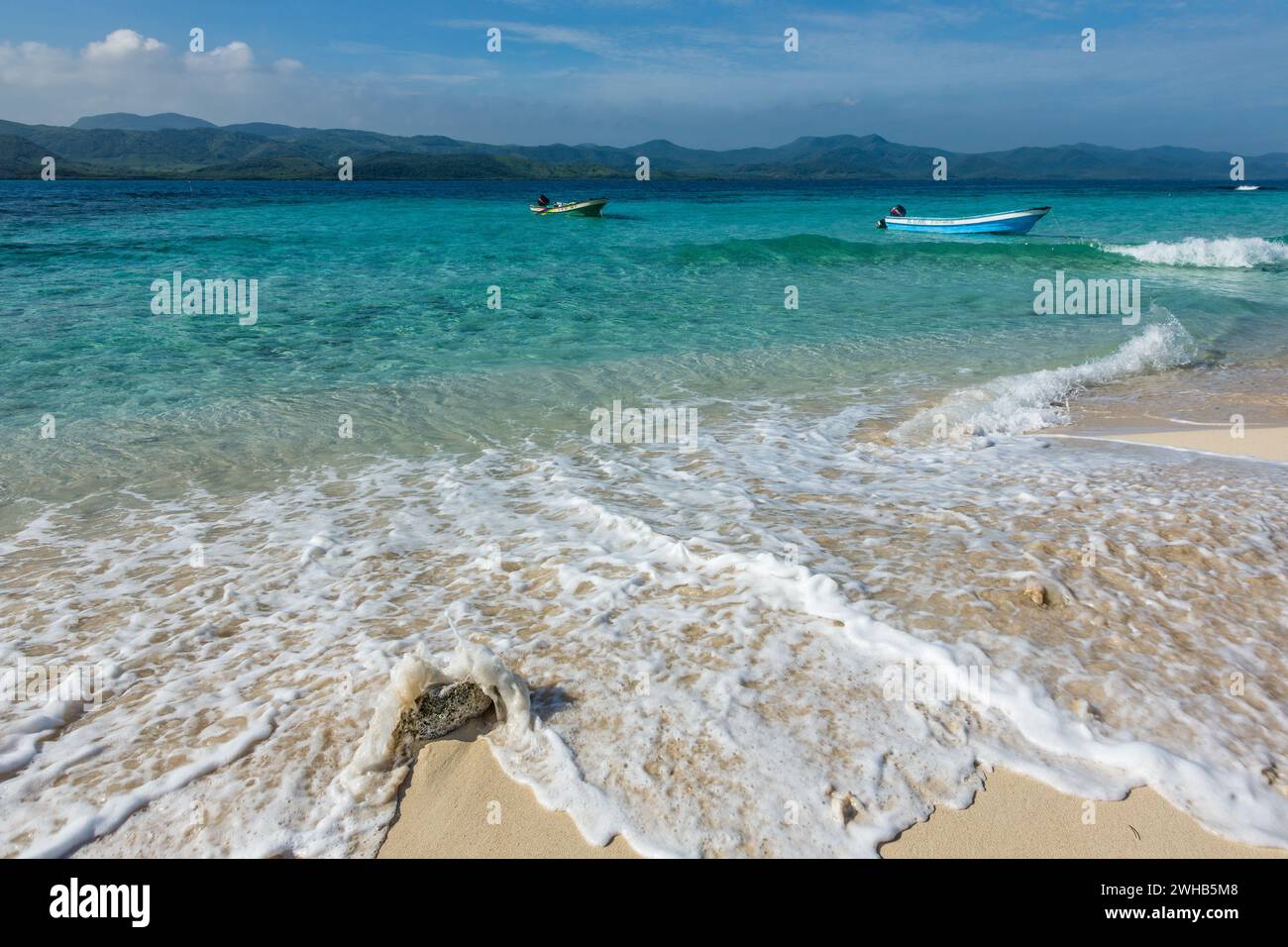 Motor launches are moored in the clear shallow water around Cayo Arena ...