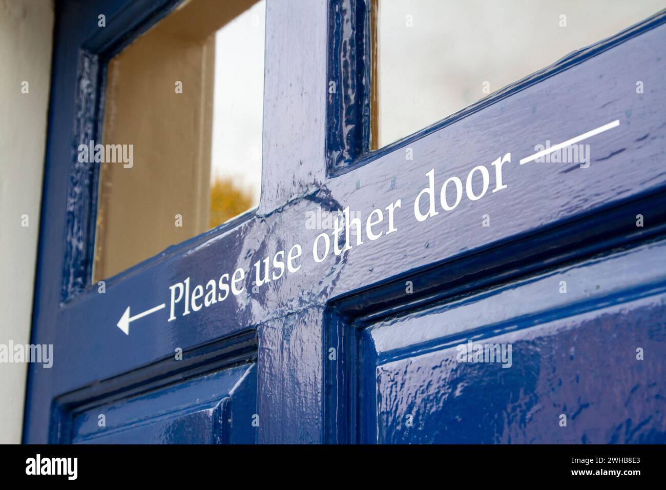 Dark blue glossy painted door has a direction arrow and the instruction ...