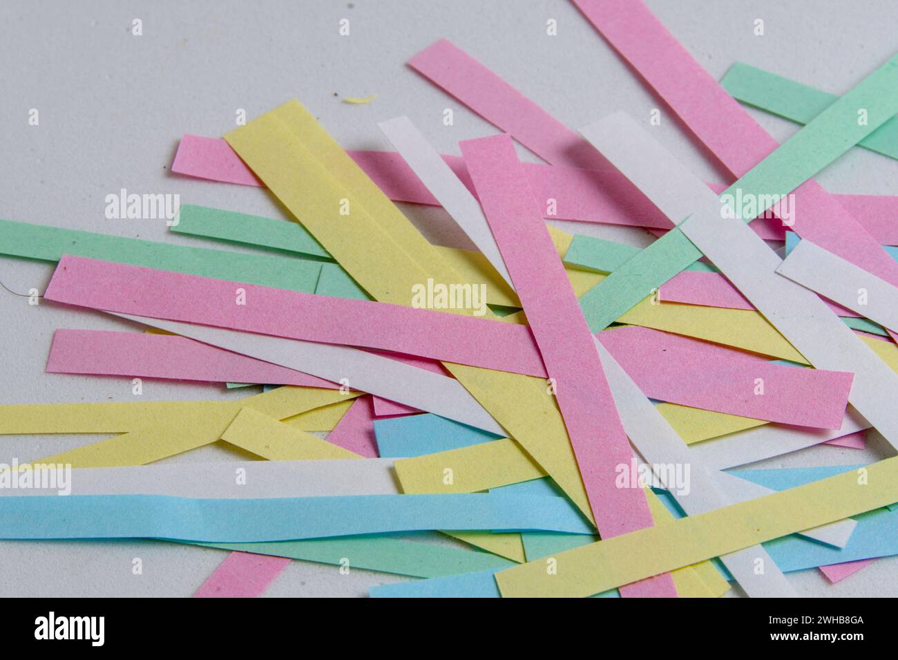 paper confetti with elongated shape in pastel colors on white ...