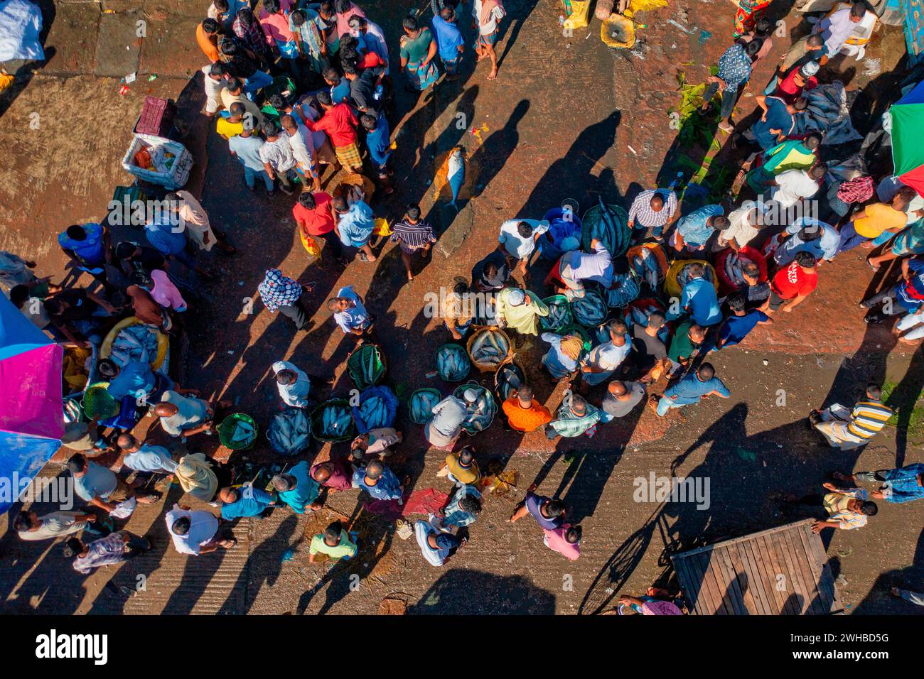 Aerial view of people working and trading at fish market along ...