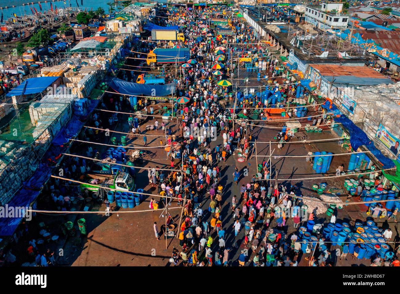Aerial view of people working and trading at fish market along ...