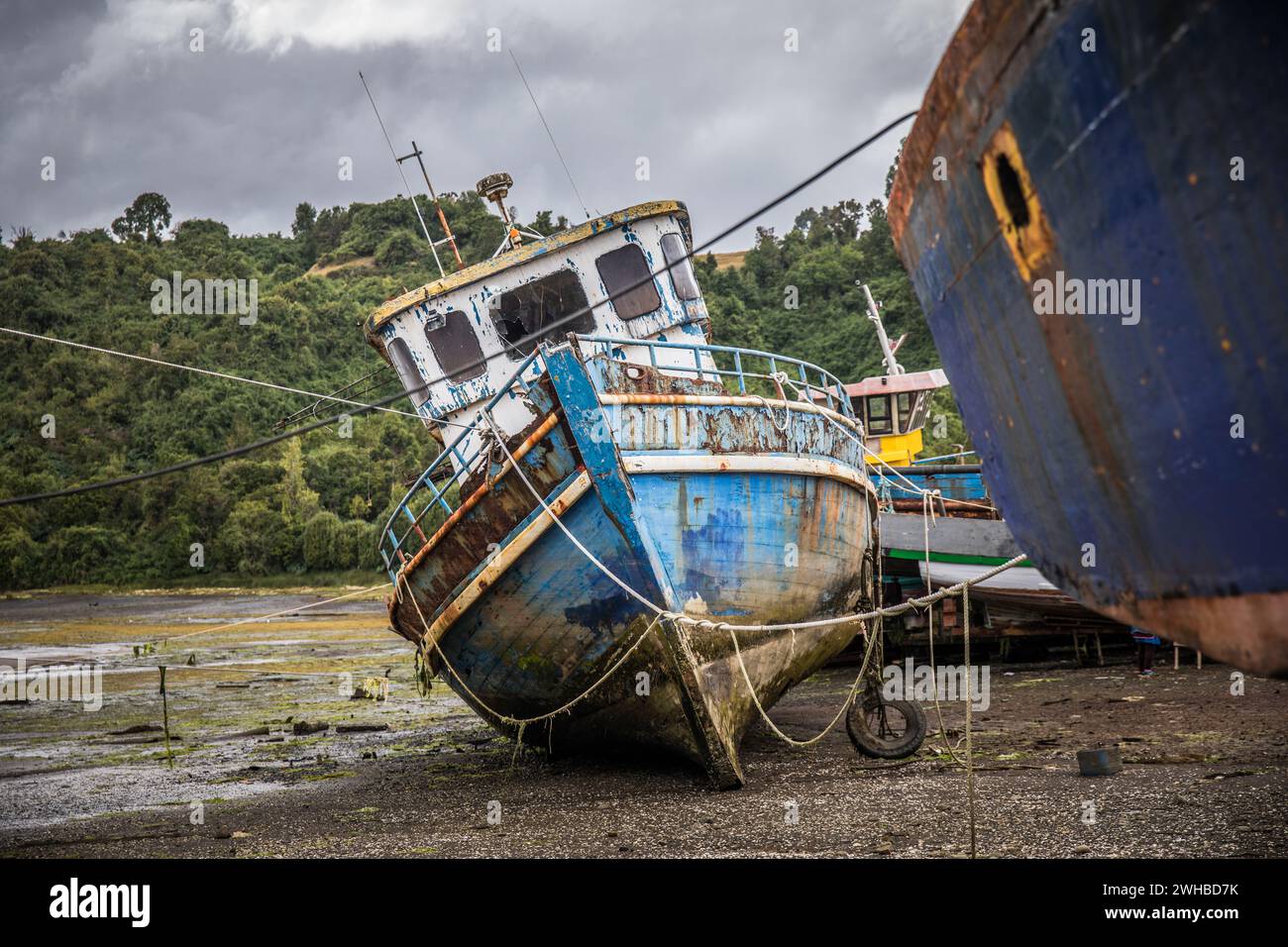 A fishing boat is stranded ashore in a small harbor on Chiloe during ...