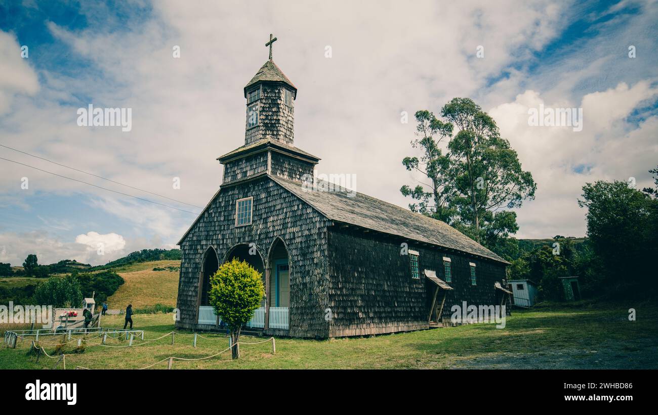 An old grayish wooden church on Chiloe with a single church tower and ...