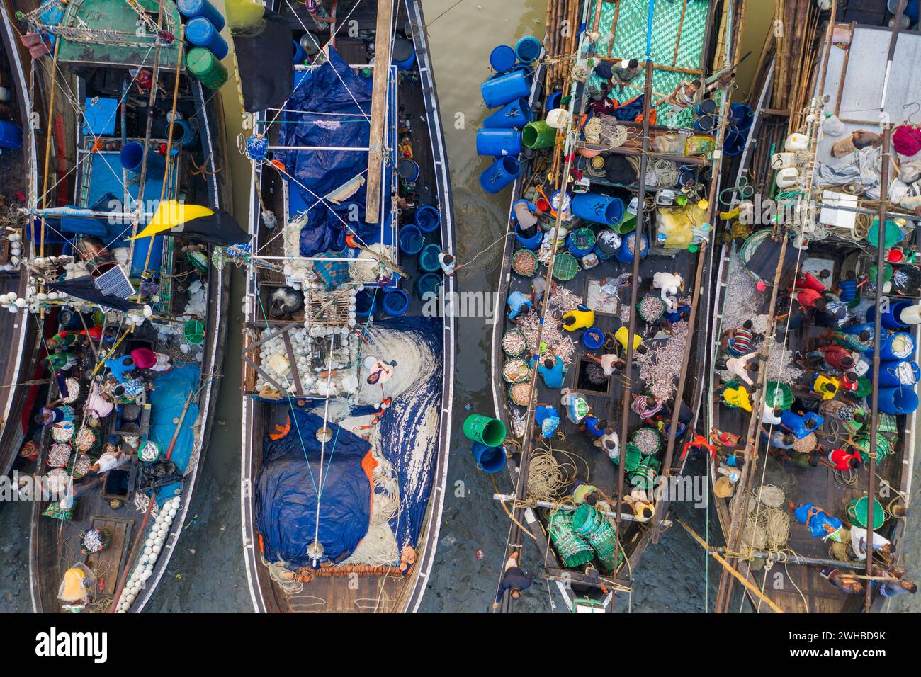 Aerial view of people working and trading at fish market along ...