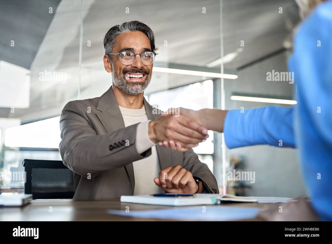 Happy middle aged business man hiring recruit at job interview ...