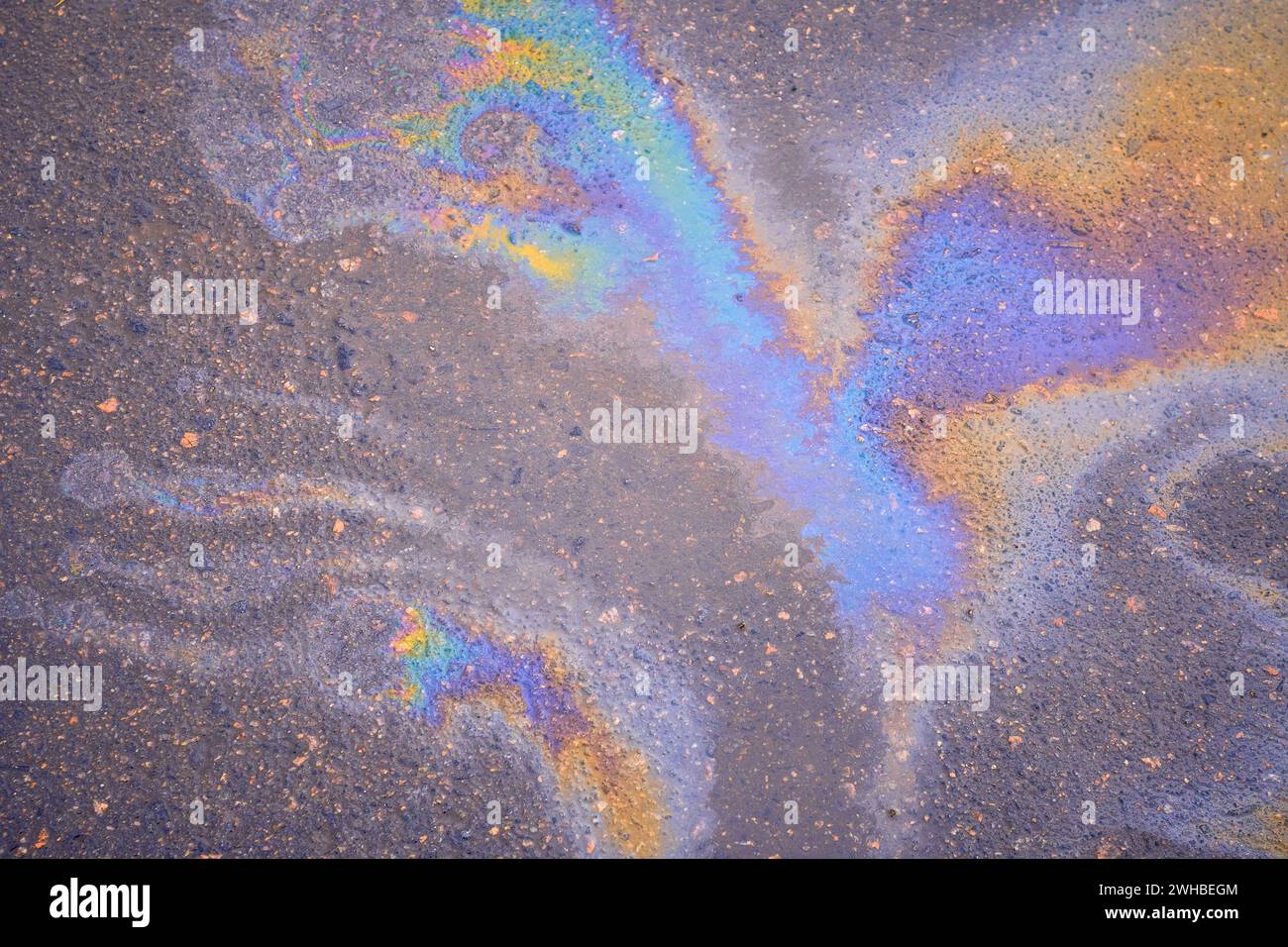 Texture of colorful petrol oil spill on wet pavement. Slick industry ...