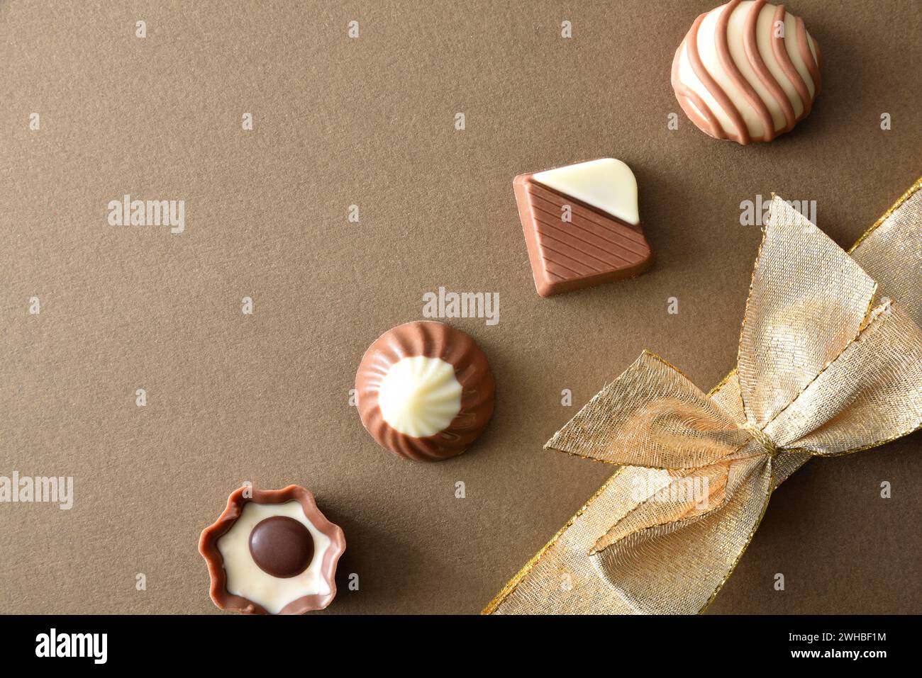 Row of different black and white milk chocolate pralines diagonally on ...