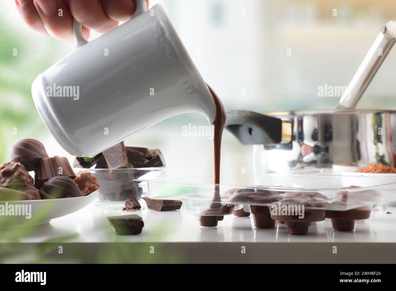 Person making chocolate bonbons on white kitchen bench at home with ... Person making chocolate bonbons on white kitchen bench at home with ...
