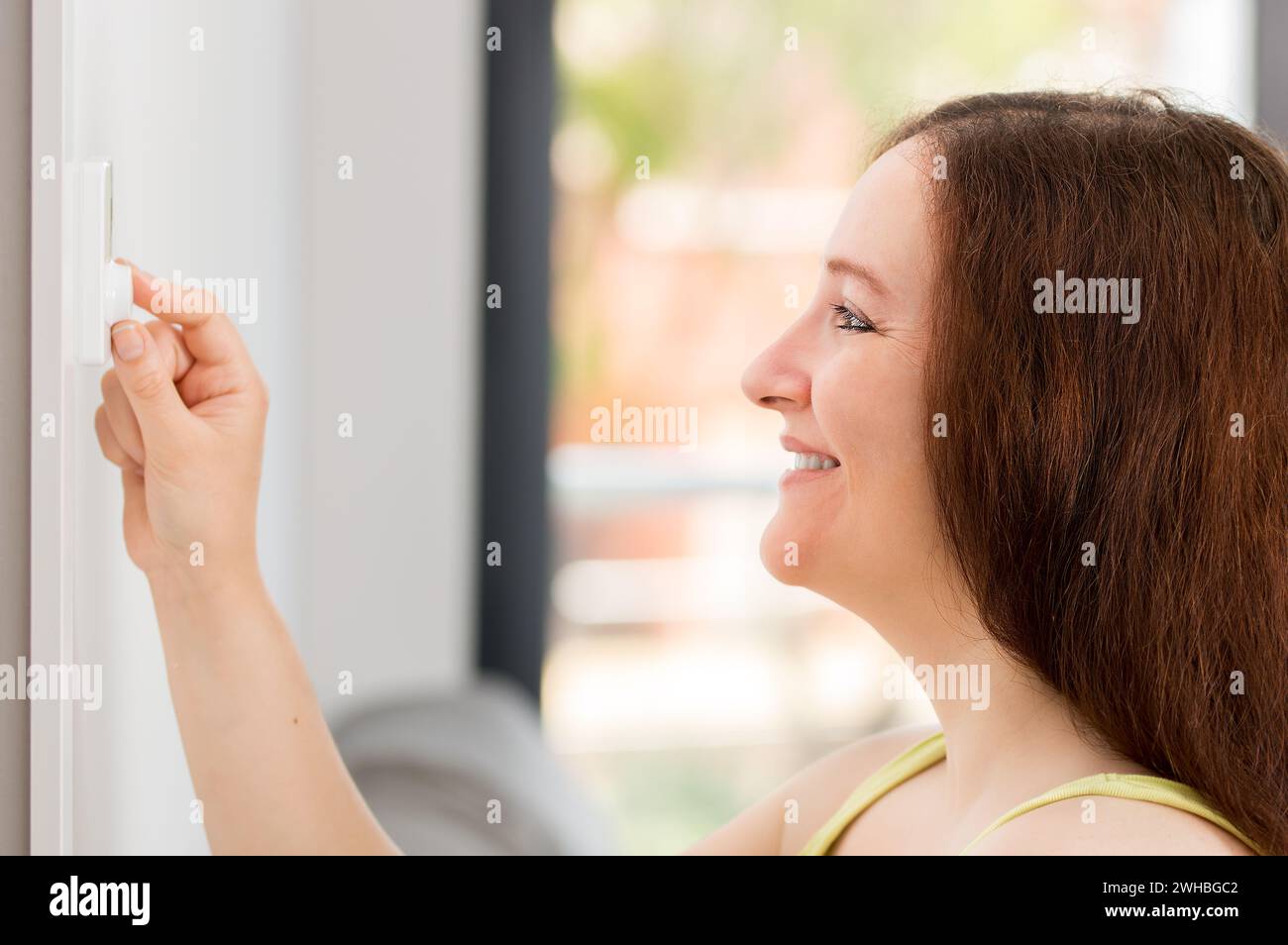 Shot of a side view portrait of a beautiful happy woman push button ...