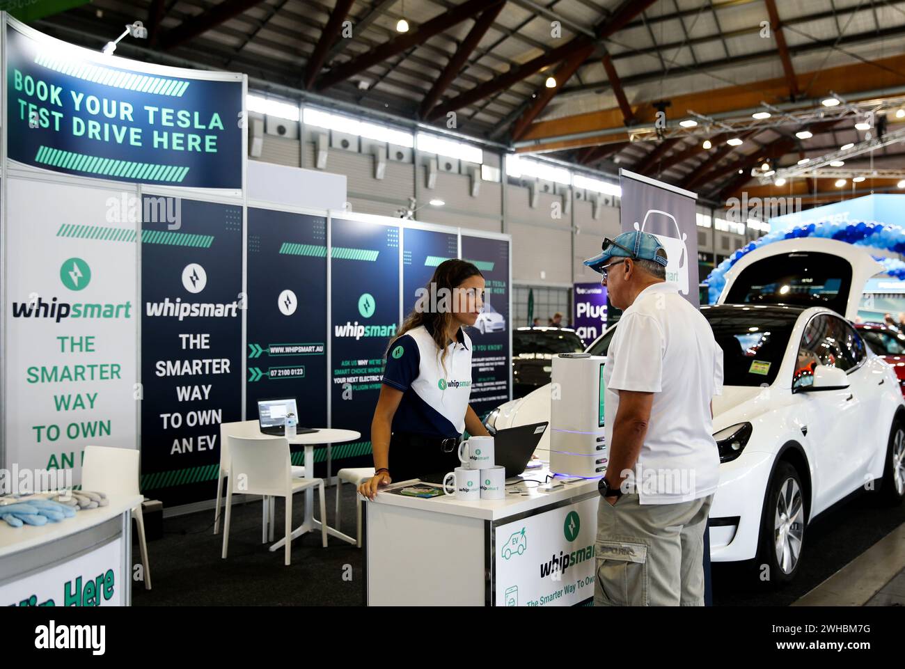 Sydney, Australia. 9th Feb, 2024. A man visits the booth of Tesla at ...