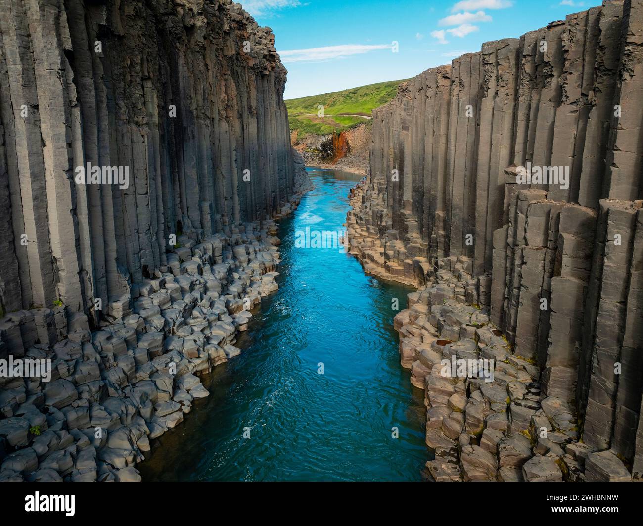 Canyon of magnificent basalt columns, high cliff with bright turquoise river, in North East ...
