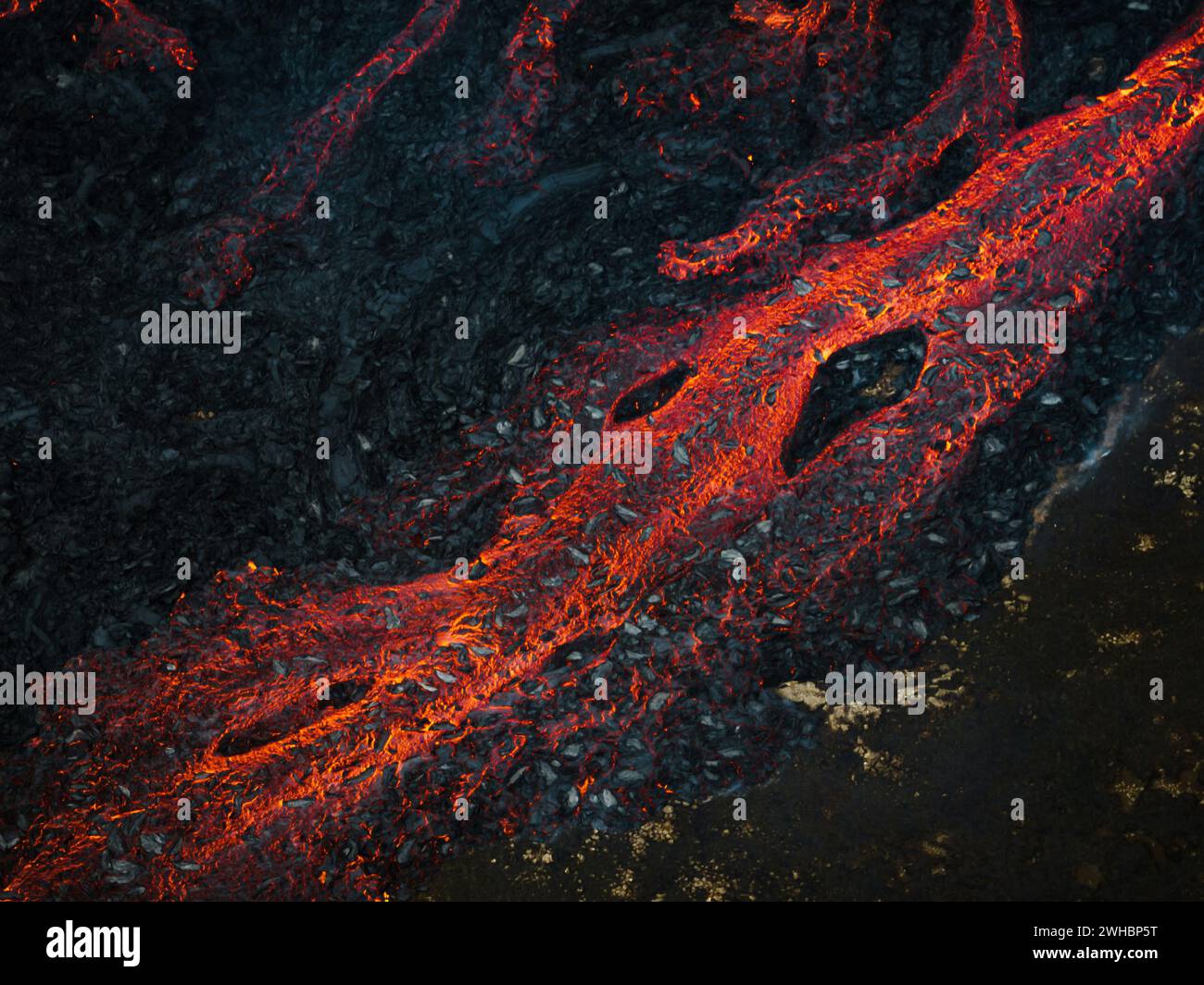 Streams of red hot lava flowing during a volcano eruption, toxic smoke ...