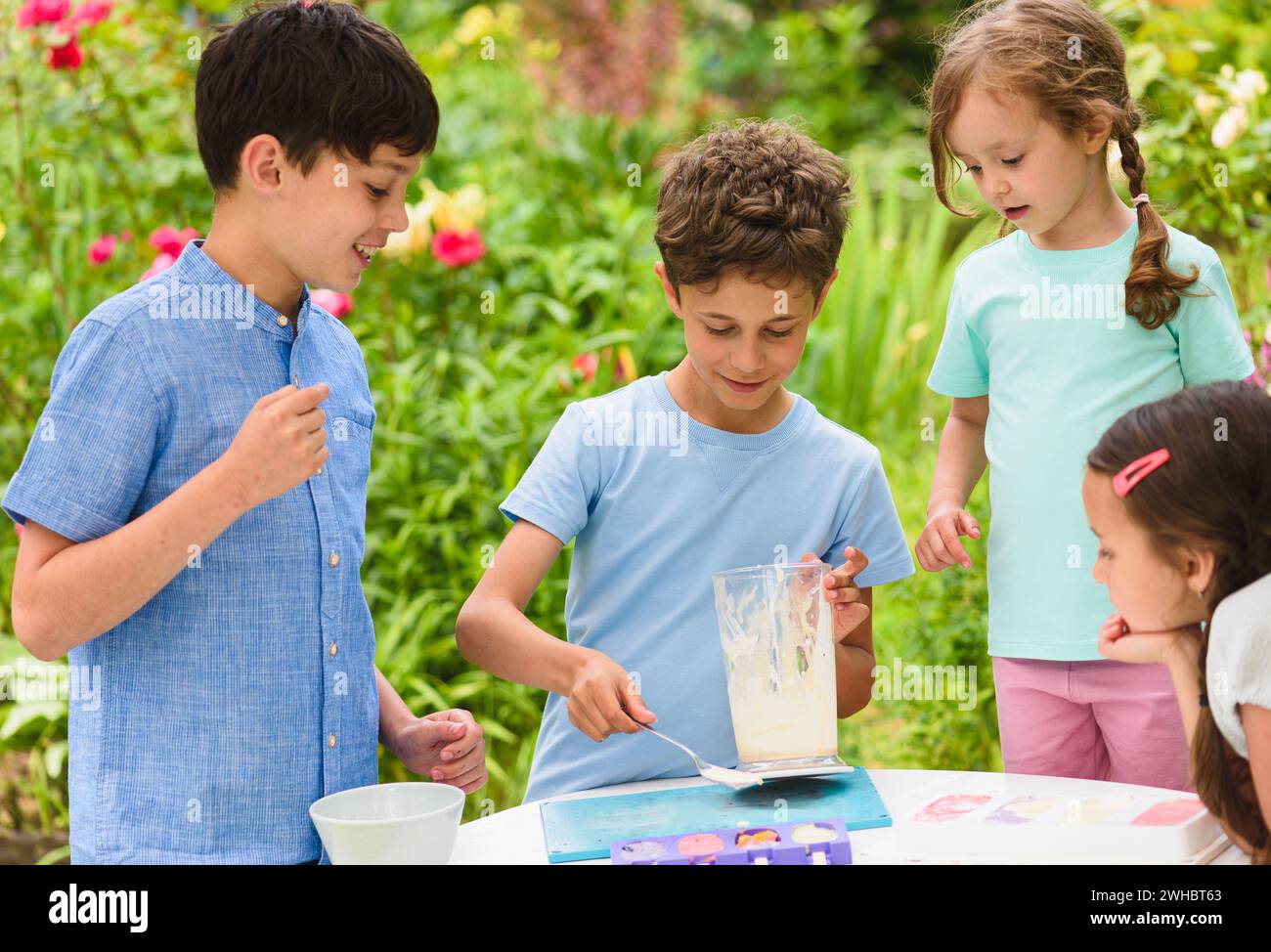 Group of children making homemade ice-cream at cooking masterclass ...