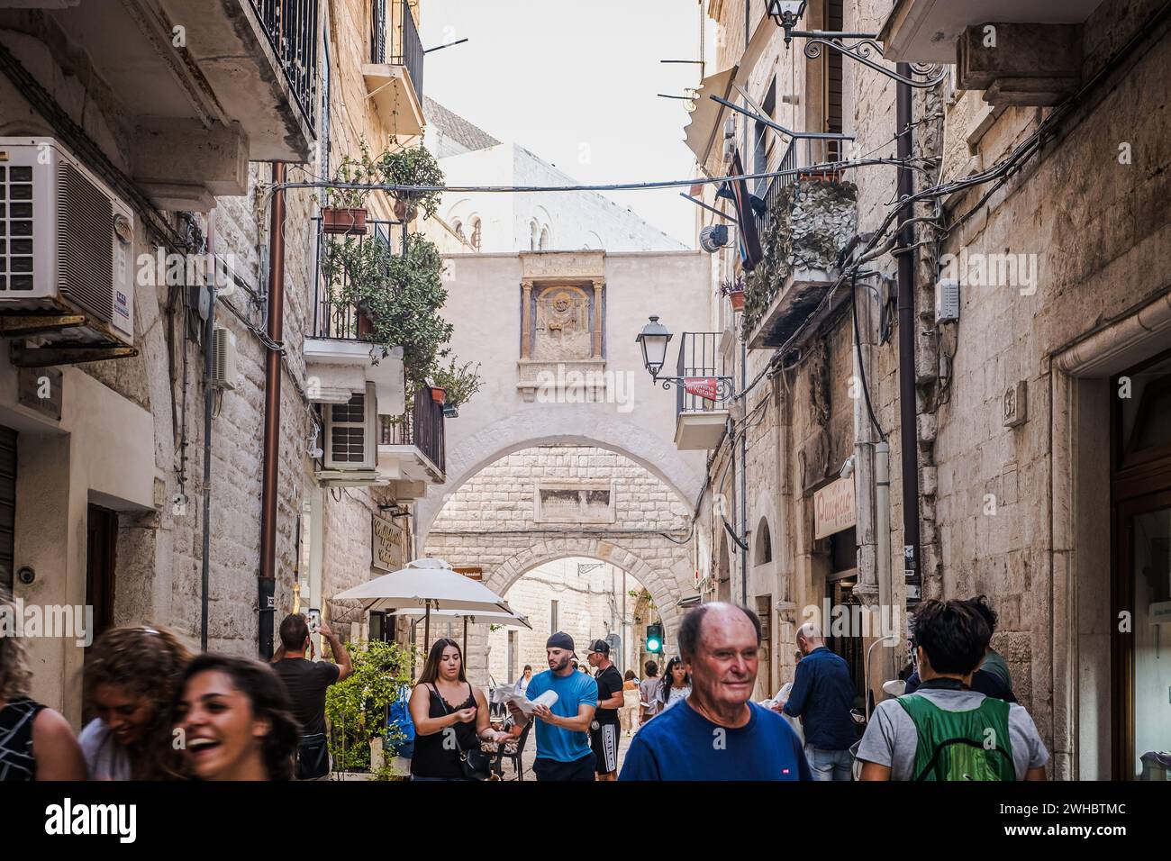 The charm of the alley of the historic center of Bari. Tourists along ...