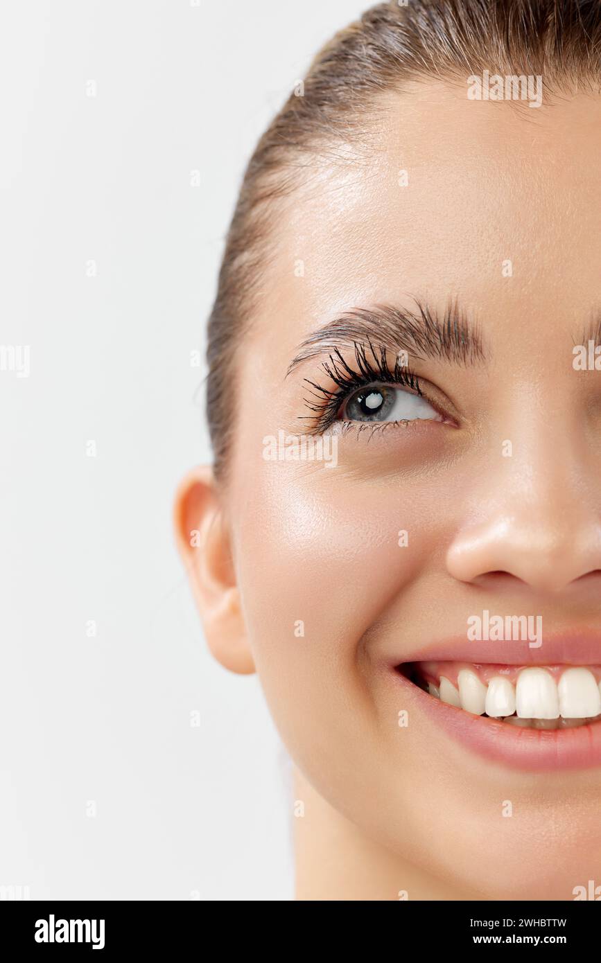 Half-faced portrait of beautiful young woman with clear face, smiling ...