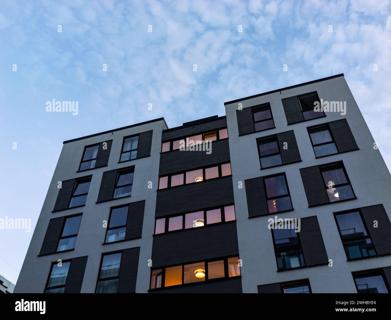 Modern residential building facade during an evening. The stairwell is ...