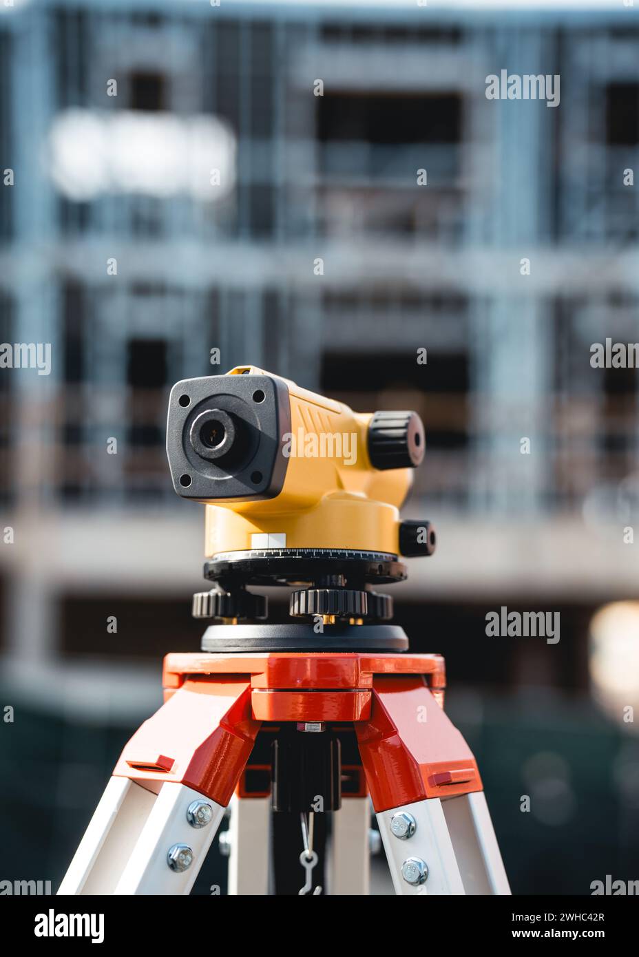 Surveying level on a tripod at the work jobsite Stock Photo - Alamy
