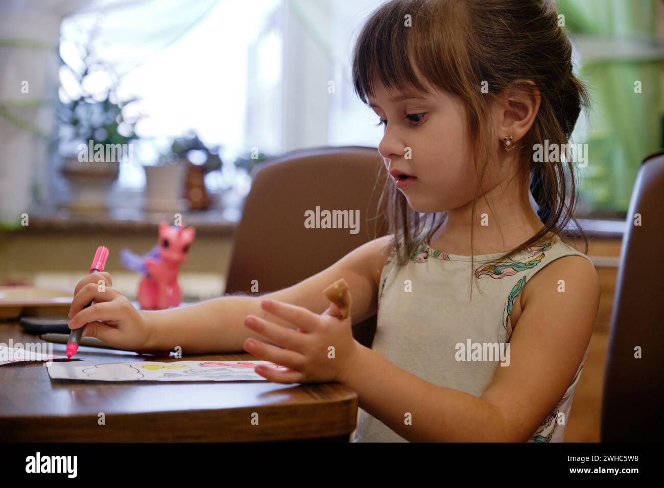 A little girl who draws a felt pen. The child is engaged in creativity ...