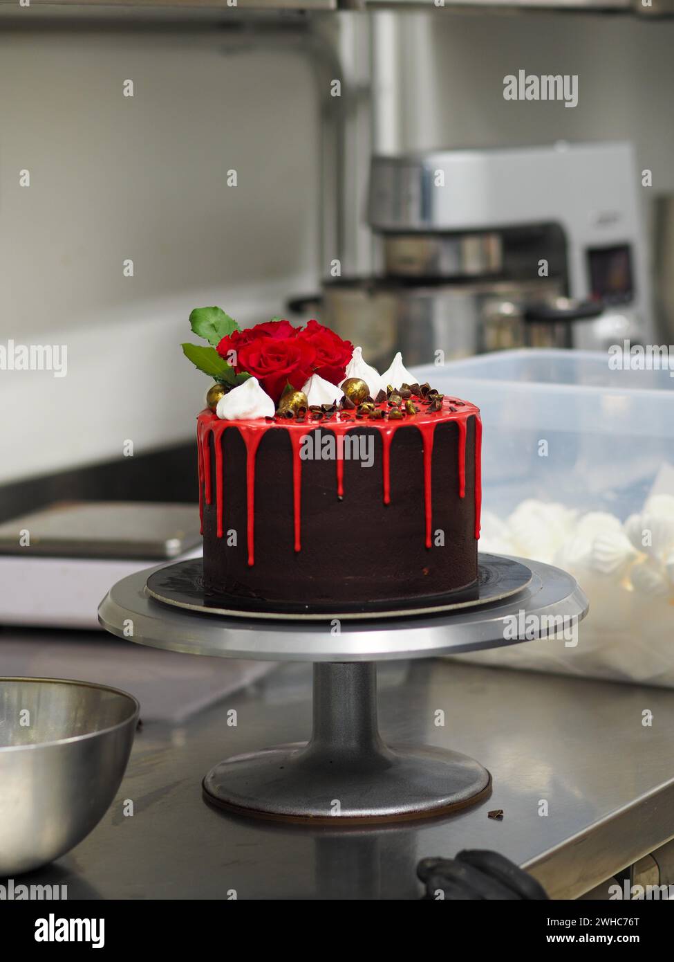 Elegant chocolate cake with red dripping icing topped with fresh roses ...