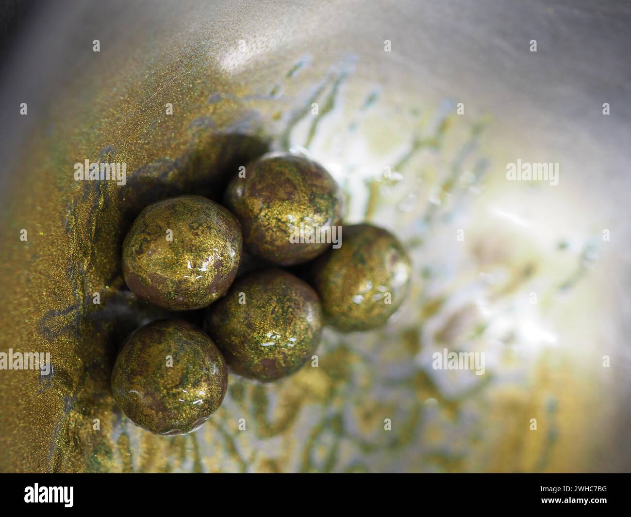 A close-up of golden sprayed edible chocolate balls used for cake ...