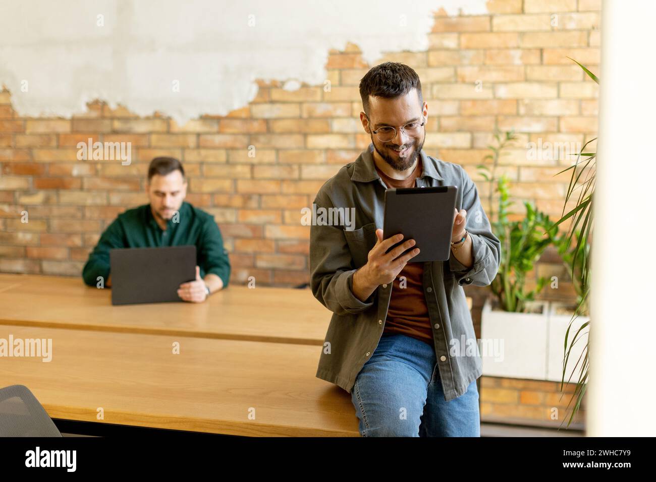 In a contemporary office setting, two focused colleagues engage in ...
