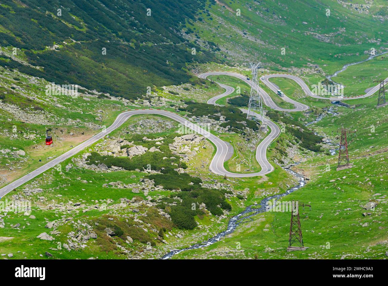 A serpentine road winds through the mountain landscape with views of ...