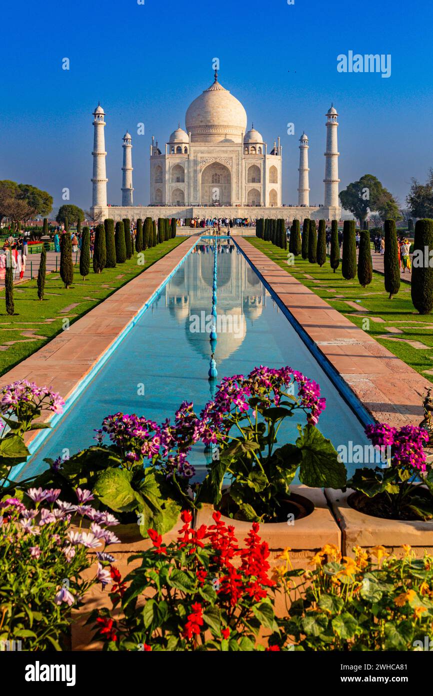 Lively scene at the Taj Mahal with a clear reflection in the water ...