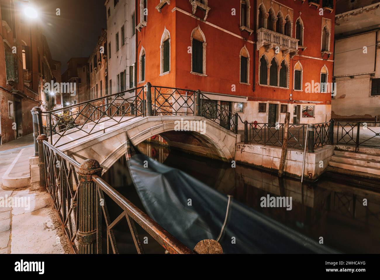 Small channel and arch bridge in lagoon city venice at night. long ...