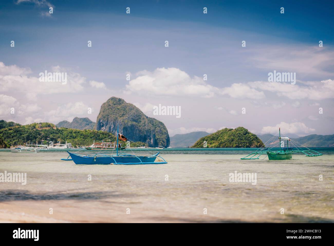Traditional banca boat in clear water at sandy Corong Beach in El Nido ...